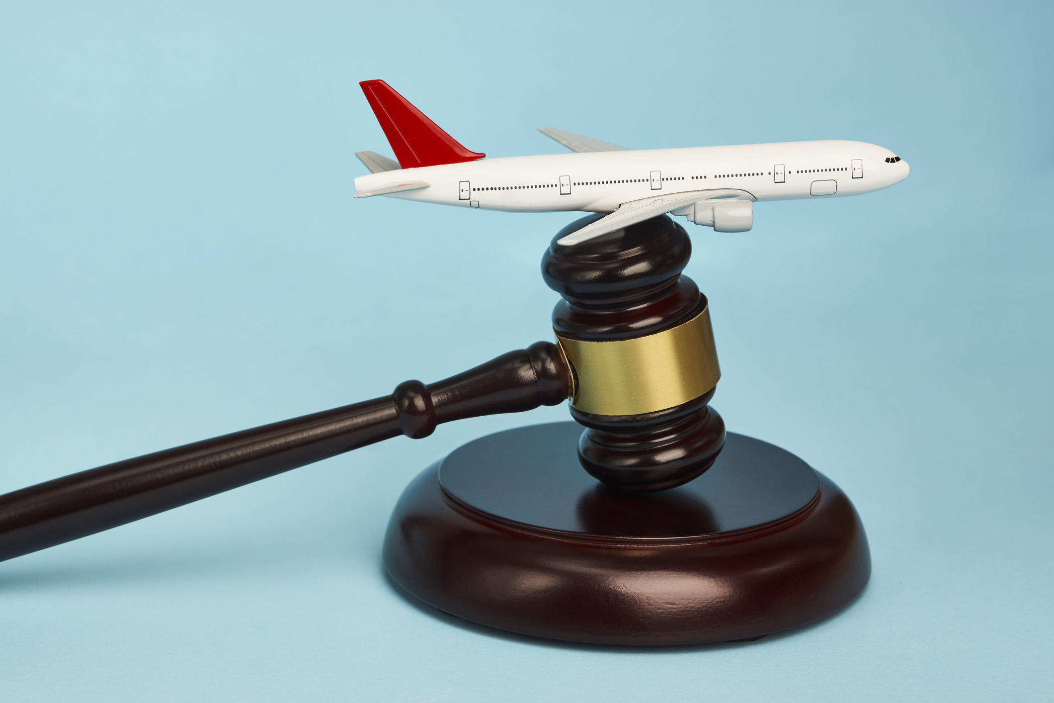 Aviation law concept. Judge gavel and airplane on blue background ...